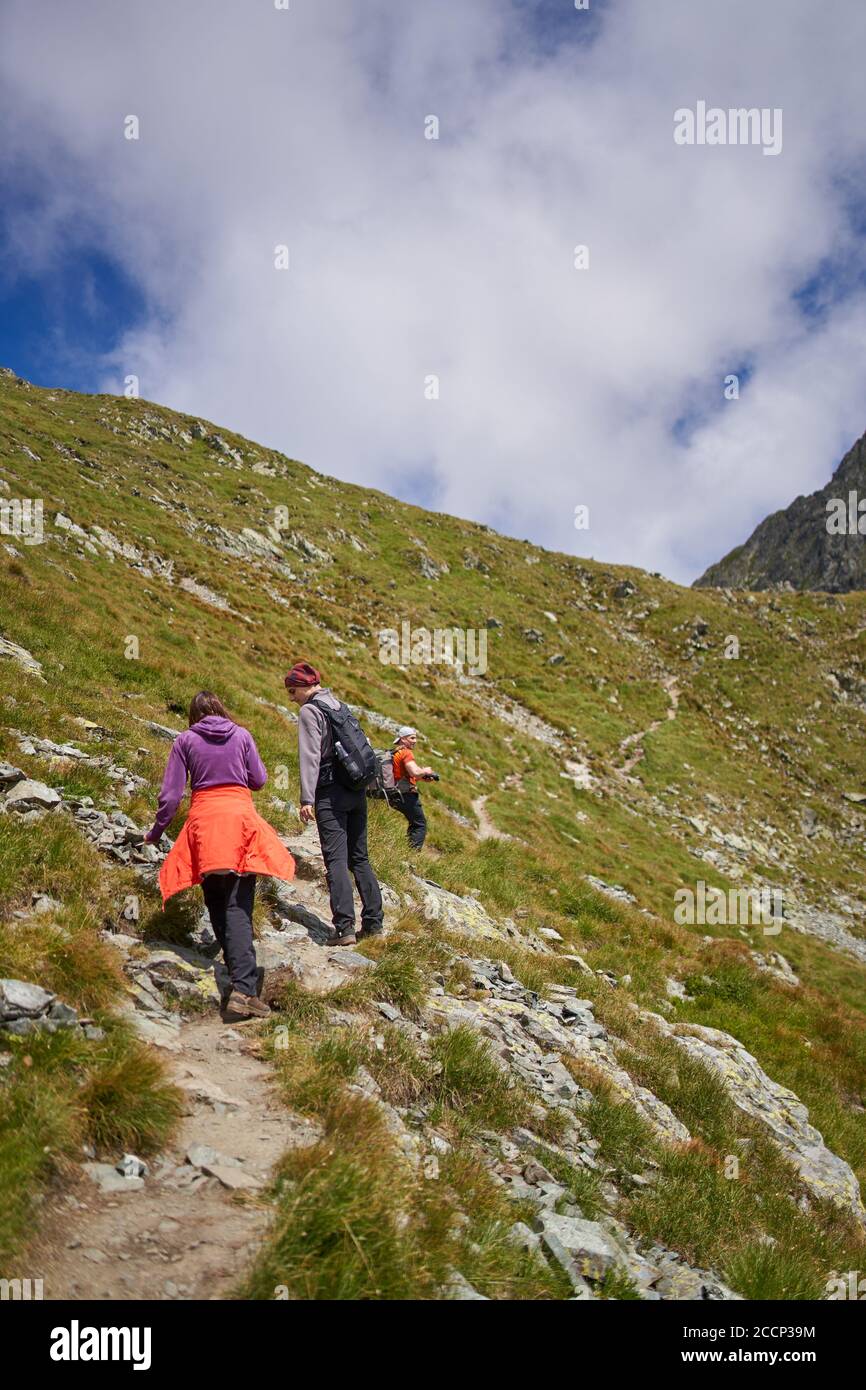 Family of hikers climbing a steep path into the mountains Stock Photo ...