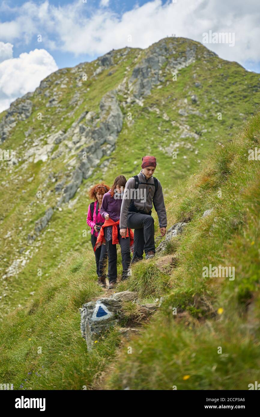 Family of hikers climbing a steep path into the mountains Stock Photo ...