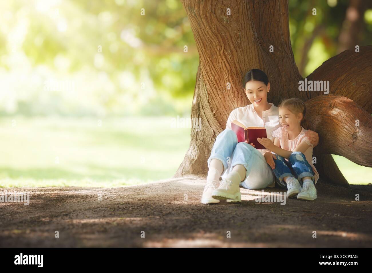 Child reading under tree hi-res stock photography and images - Alamy