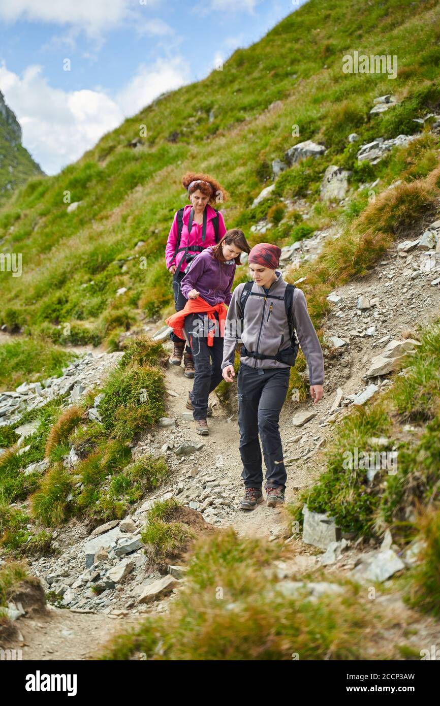 Family of hikers climbing a steep path into the mountains Stock Photo ...
