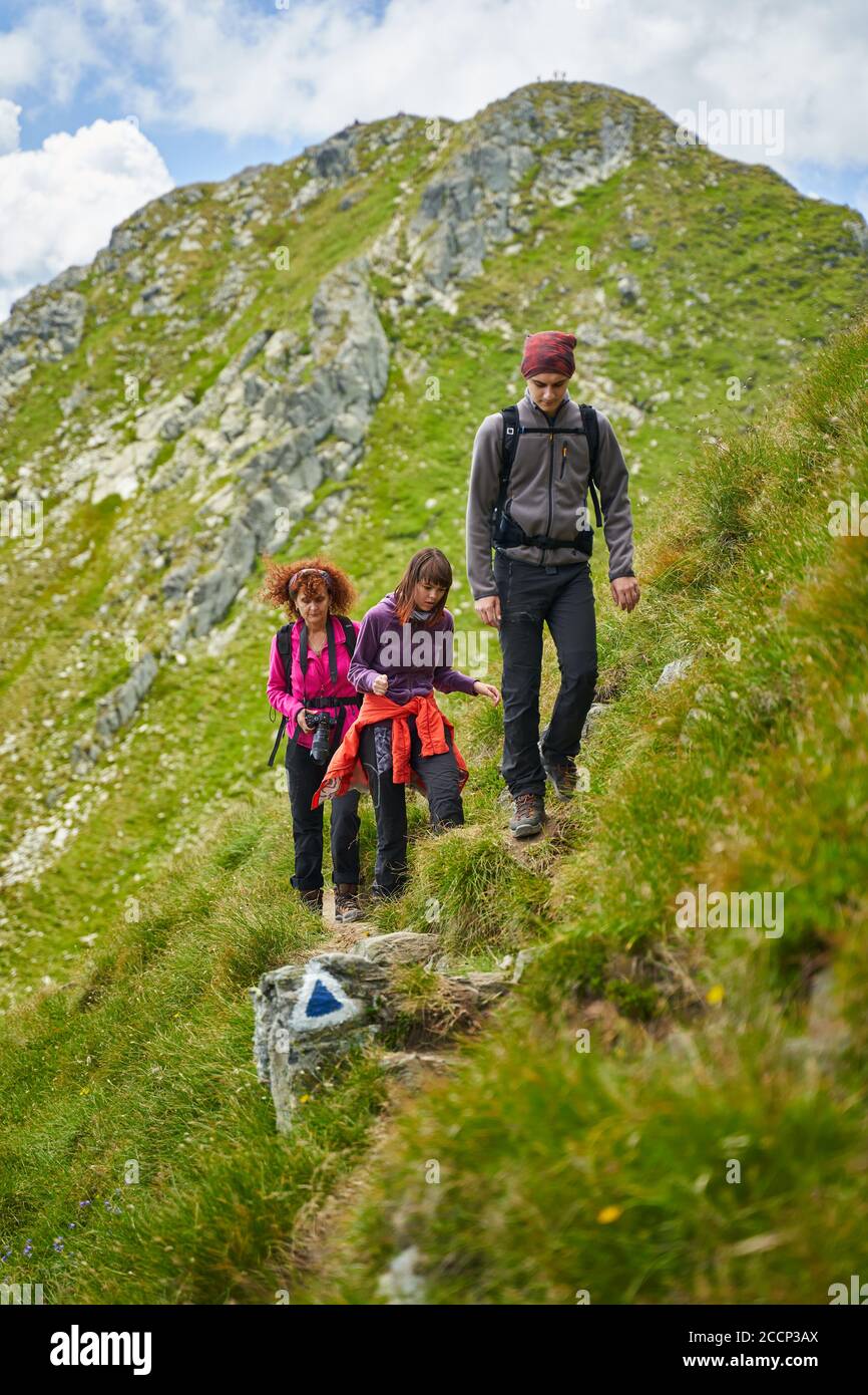Family of hikers climbing a steep path into the mountains Stock Photo ...