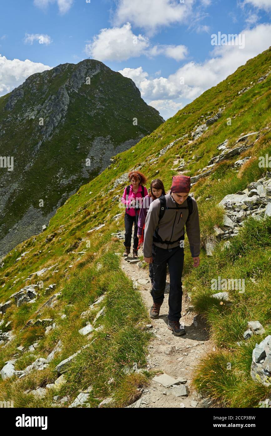 Family of hikers climbing a steep path into the mountains Stock Photo ...