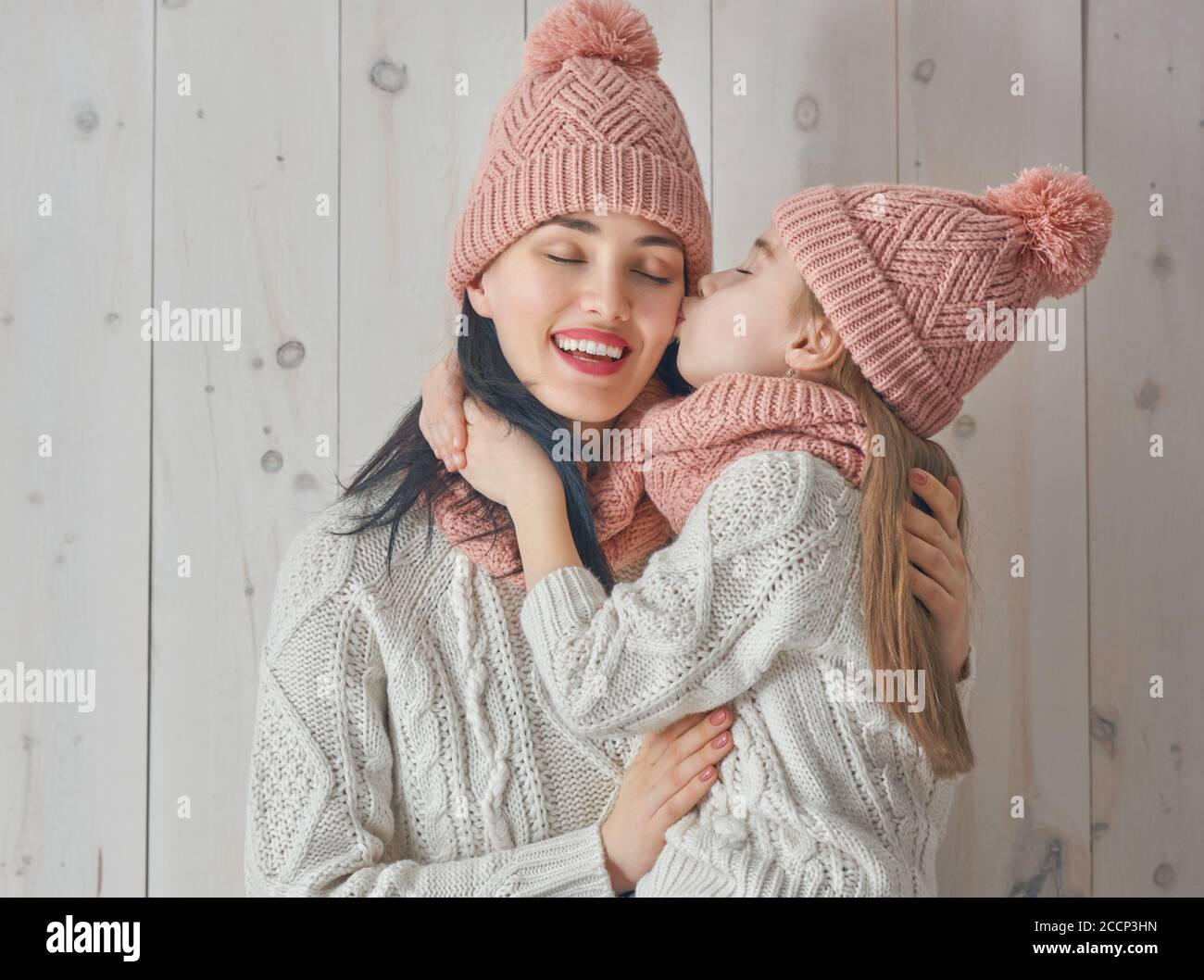 Winter portrait of happy loving family wearing knitted hats, snoods and ...