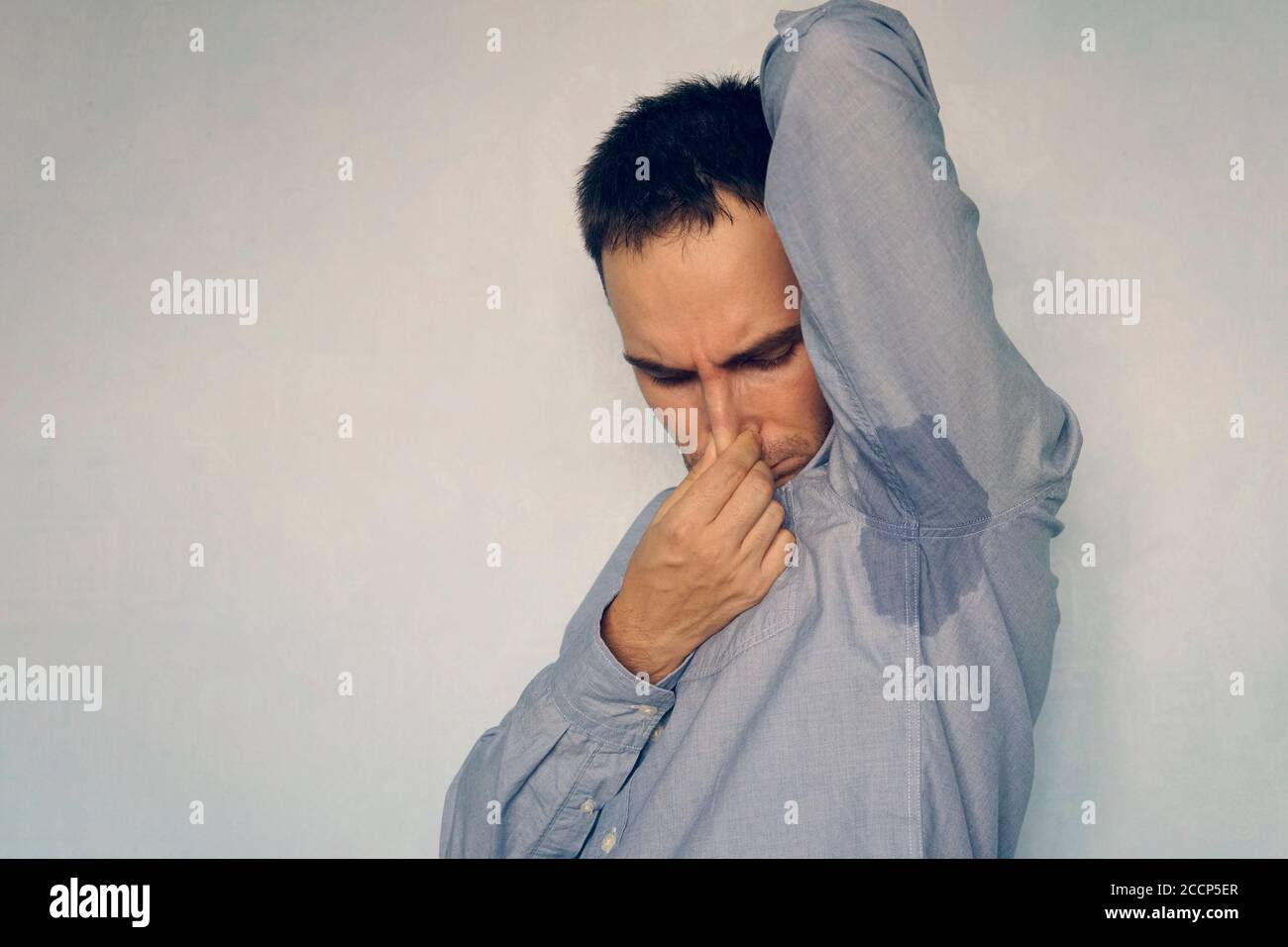 Closeup portrait young Man, Smelling sniffing Armpit, something Stinks ...