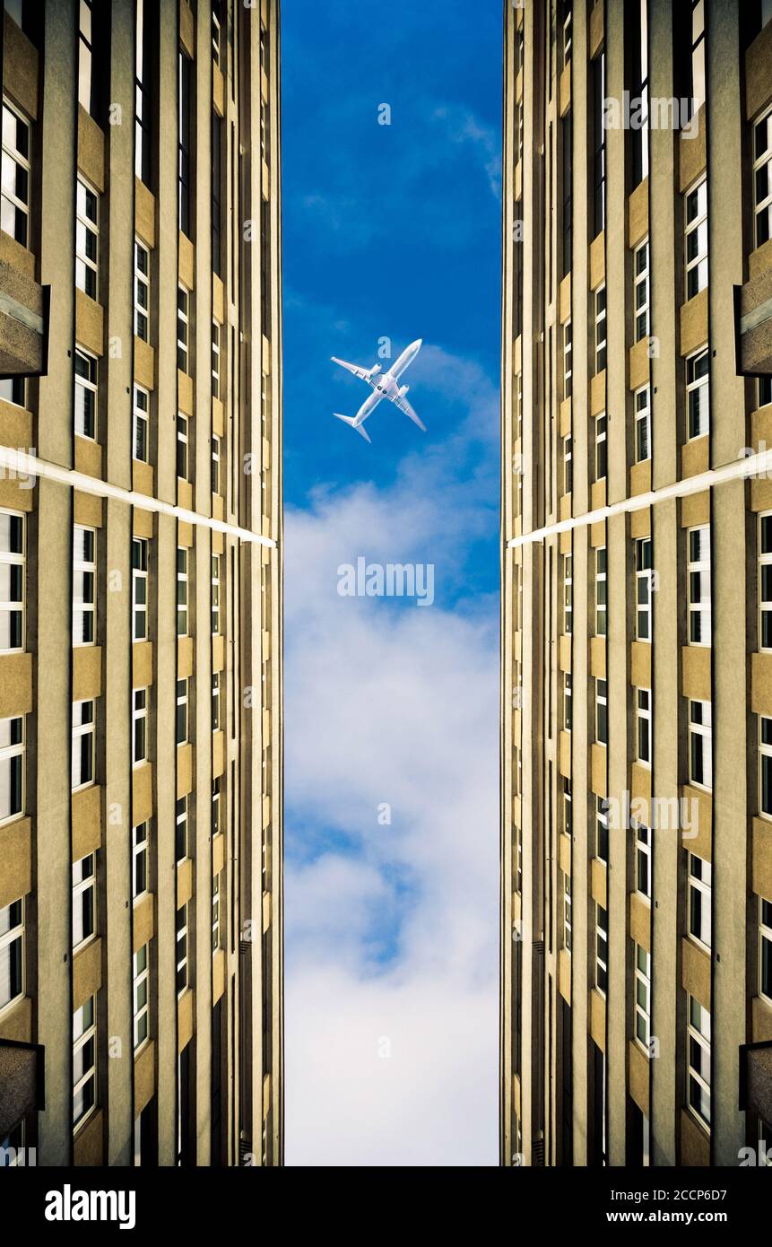 airplane flying between buildings Stock Photo - Alamy