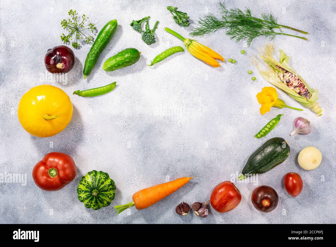 Fresh select seasonal vegetables on light textured backdrop, top view w ...