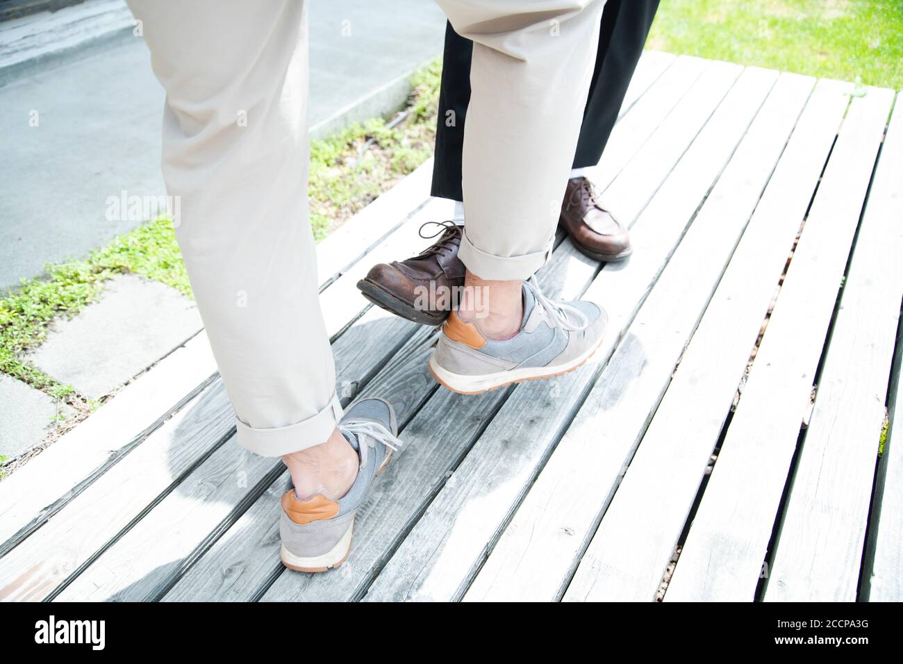 Young Man and Mature Man are doing Foot Shake Greeting as an ...