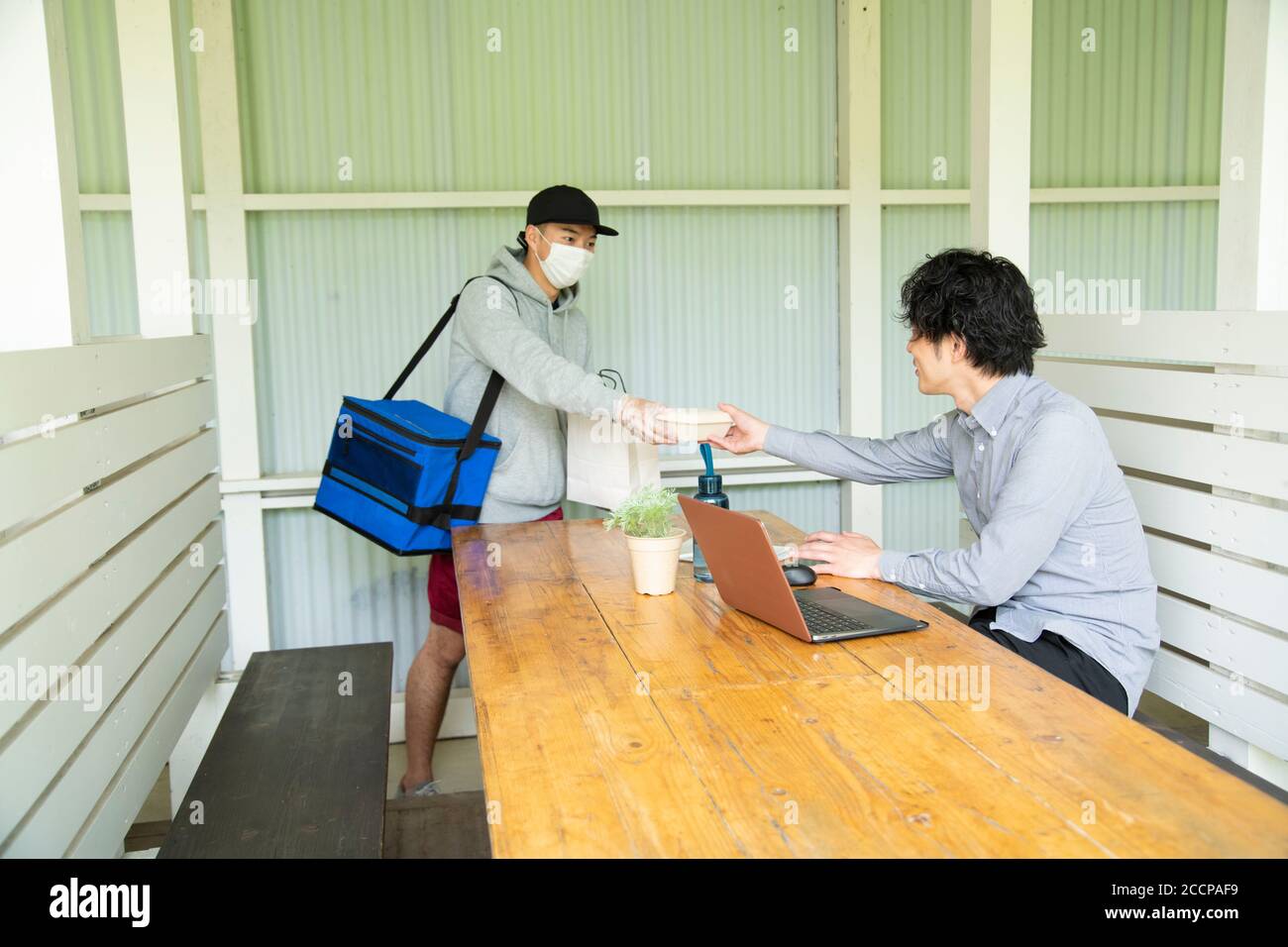 Mature Man Receiving Lunch Box from Delivery Person Stock Photo - Alamy