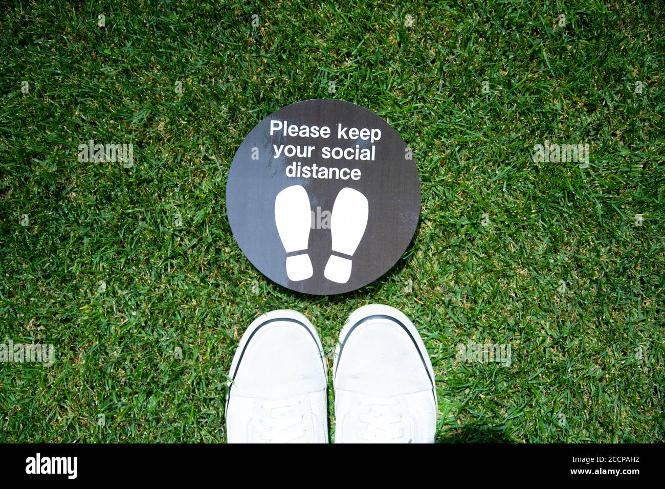 Young Man's Feet and Social Distance Sign Stock Photo - Alamy