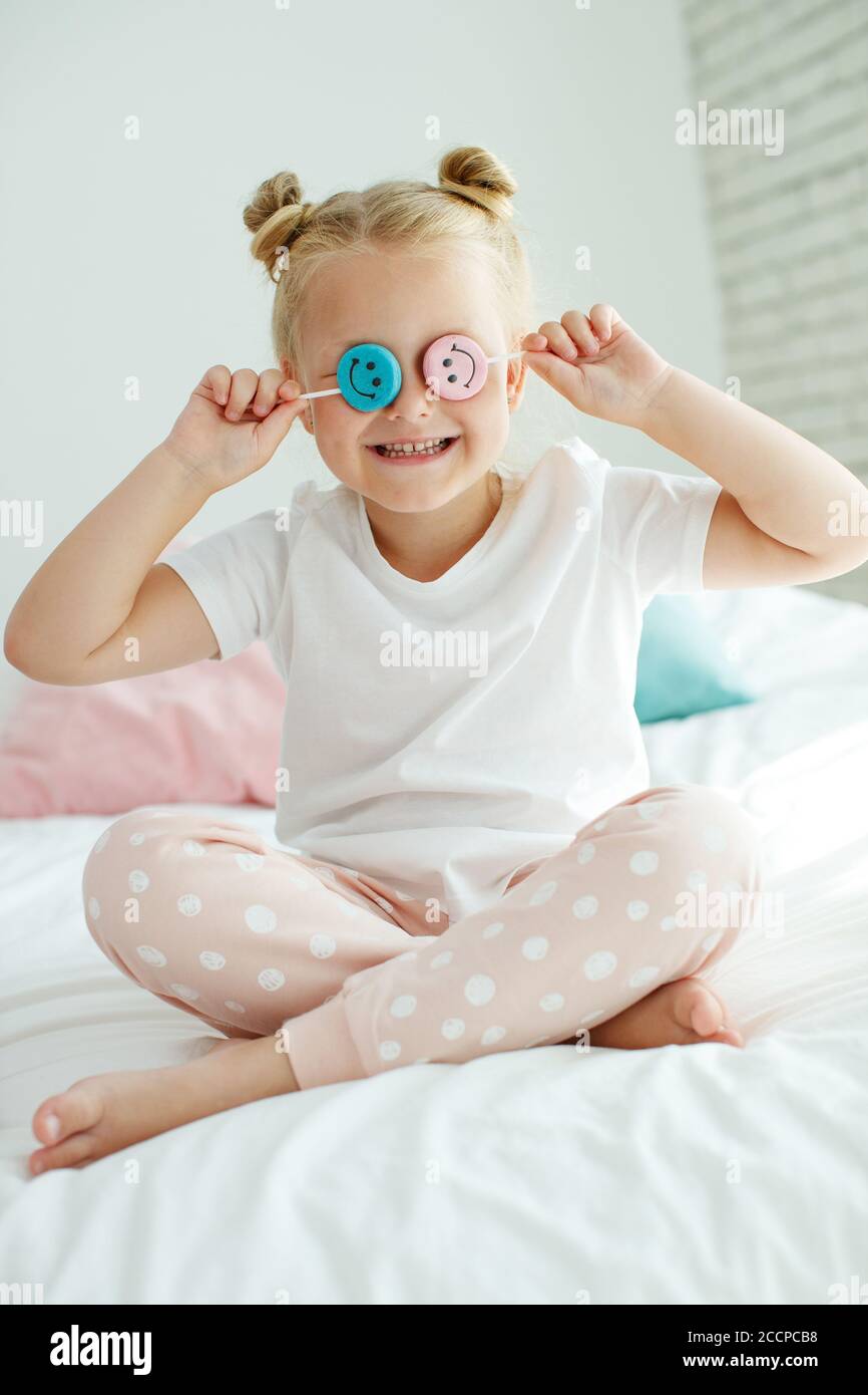 Child with candy. A little girl is holding two candies in her hands ...