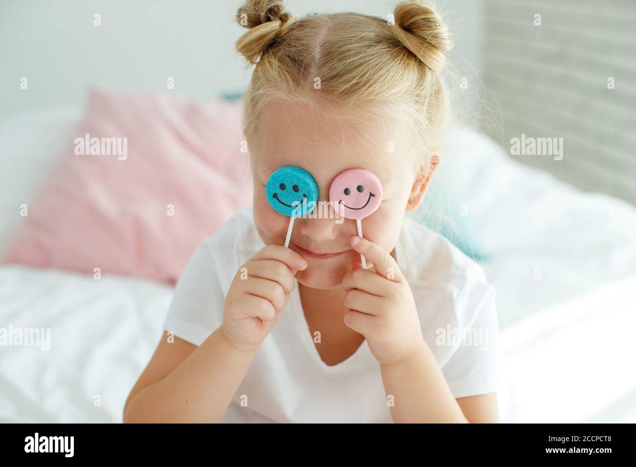 Child with candy. A little girl is holding two candies in her hands ...