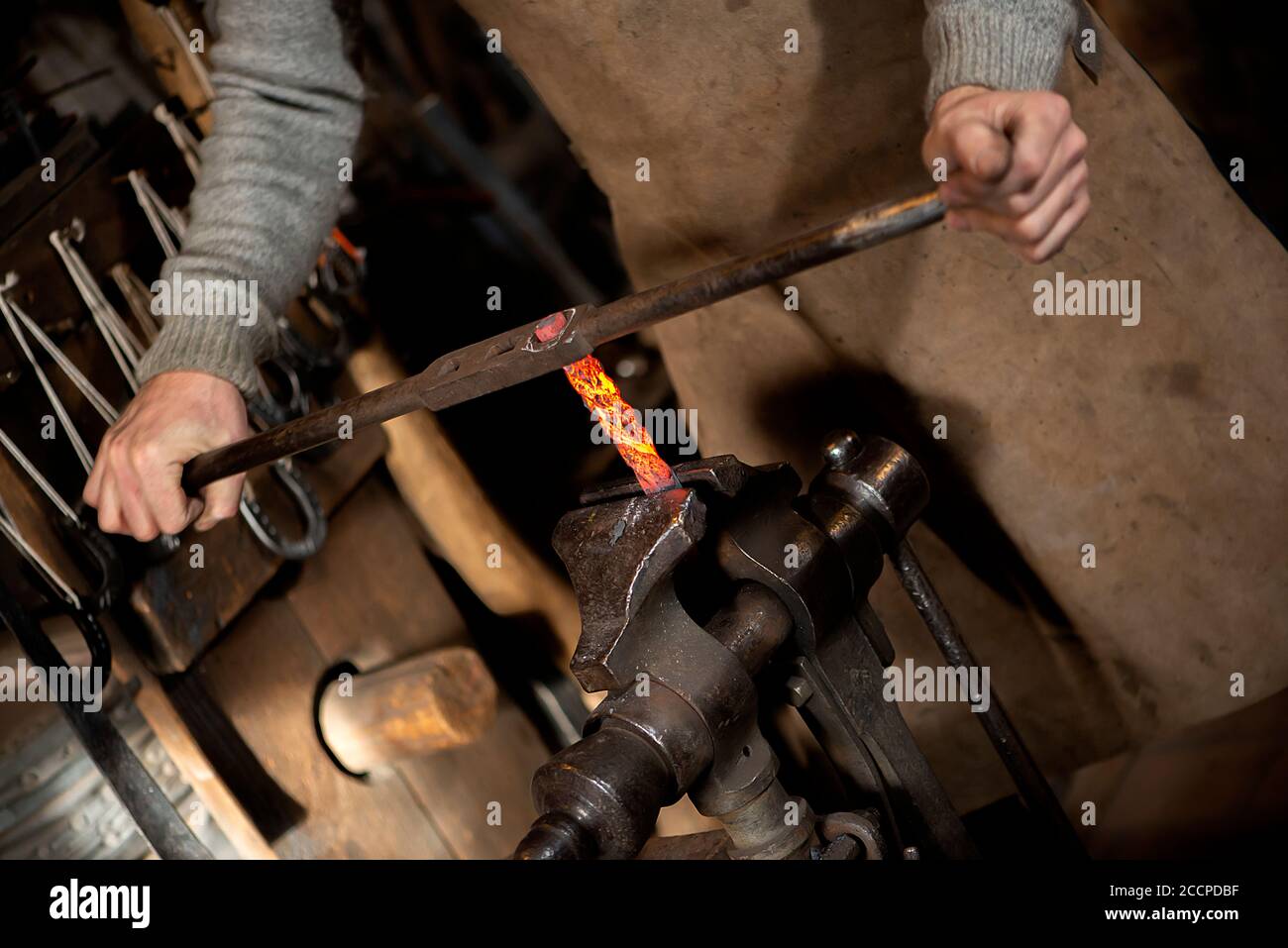 Close-up of blacksmith hands holding working tools Stock Photo - Alamy