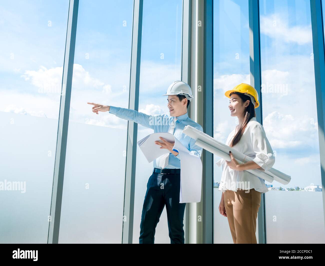 Asian architect Male and female inspecting construction work inside ...