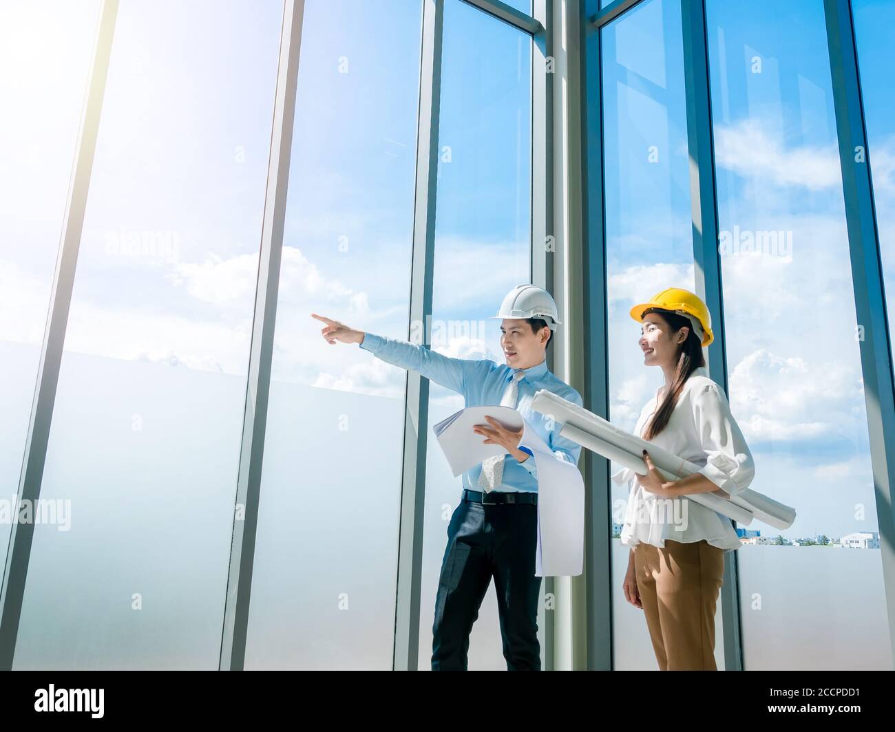 Asian architect Male and female inspecting construction work inside ...