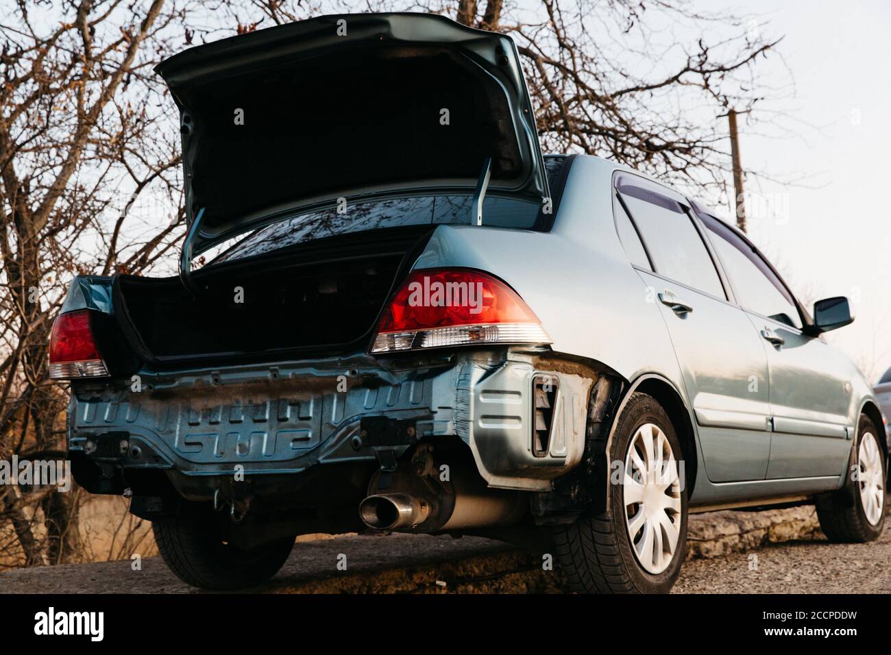 A car without a bumper, the exhaust pipe is visible. The boot lid is ...