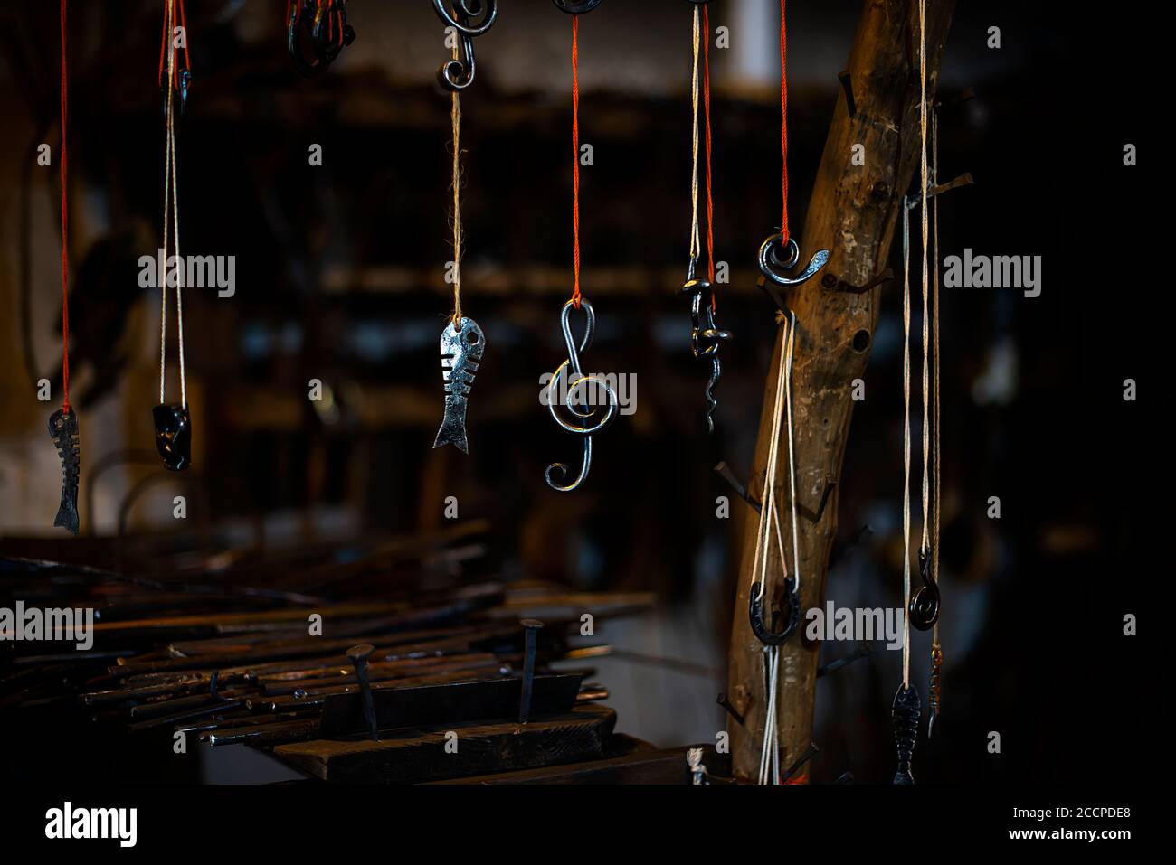 Blacksmith decorative elements hanging at forge, workshop. Handmade ...