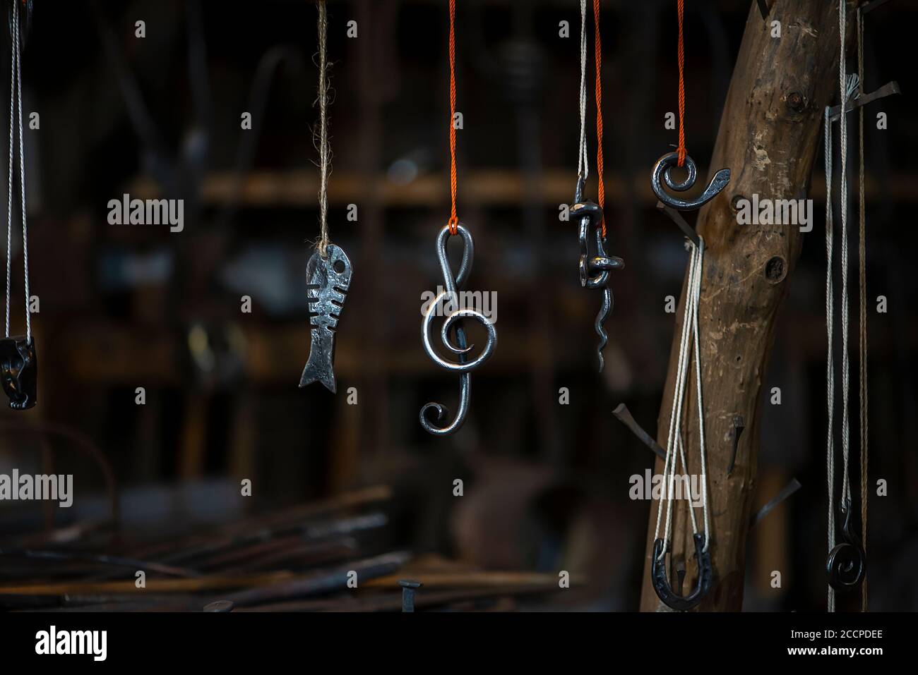 Blacksmith decorative elements hanging at forge, workshop. Handmade ...