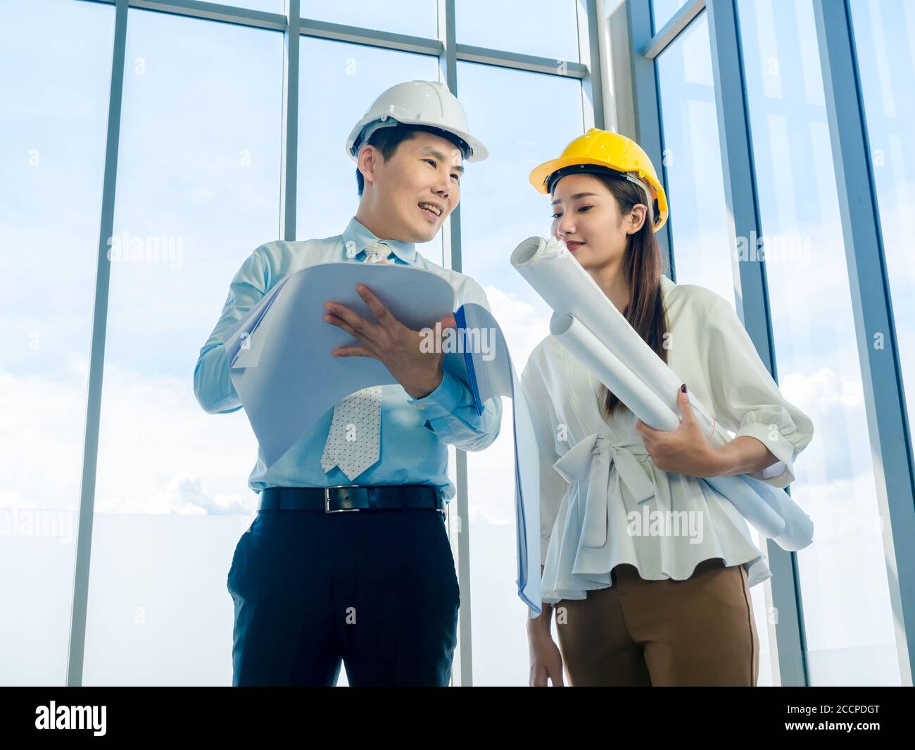 Asian architect Male and female inspecting construction work inside ...