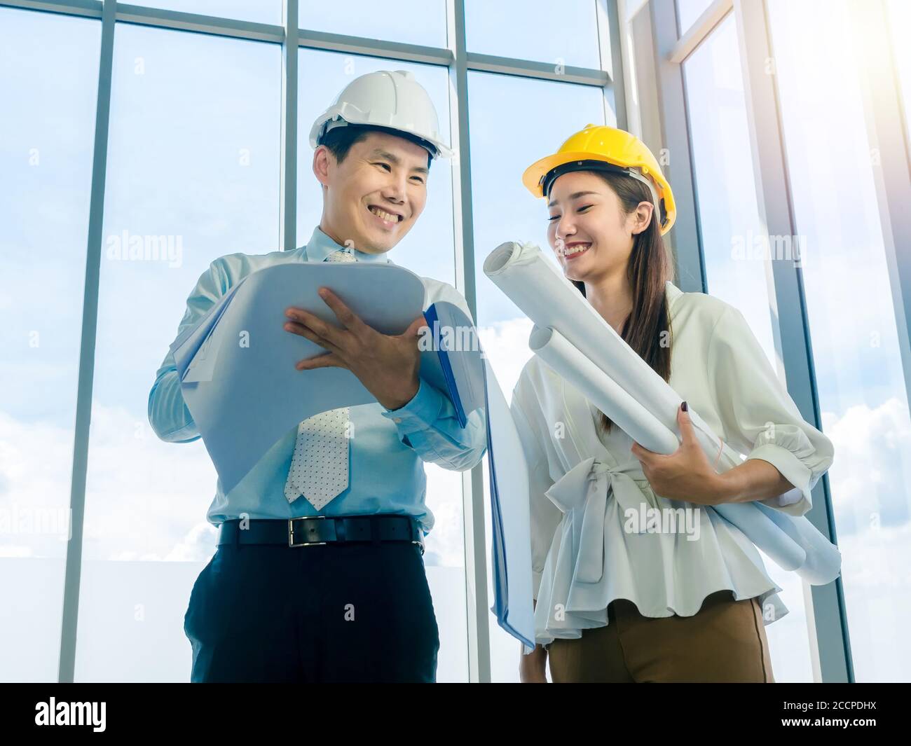 Asian architect Male and female inspecting construction work inside ...
