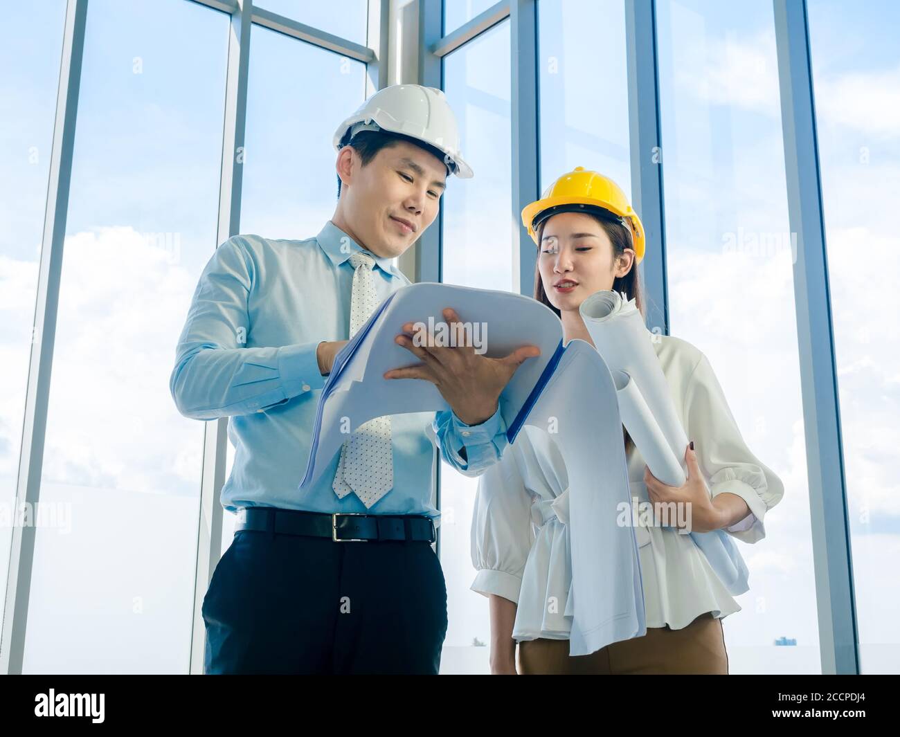 Asian architect Male and female inspecting construction work inside ...