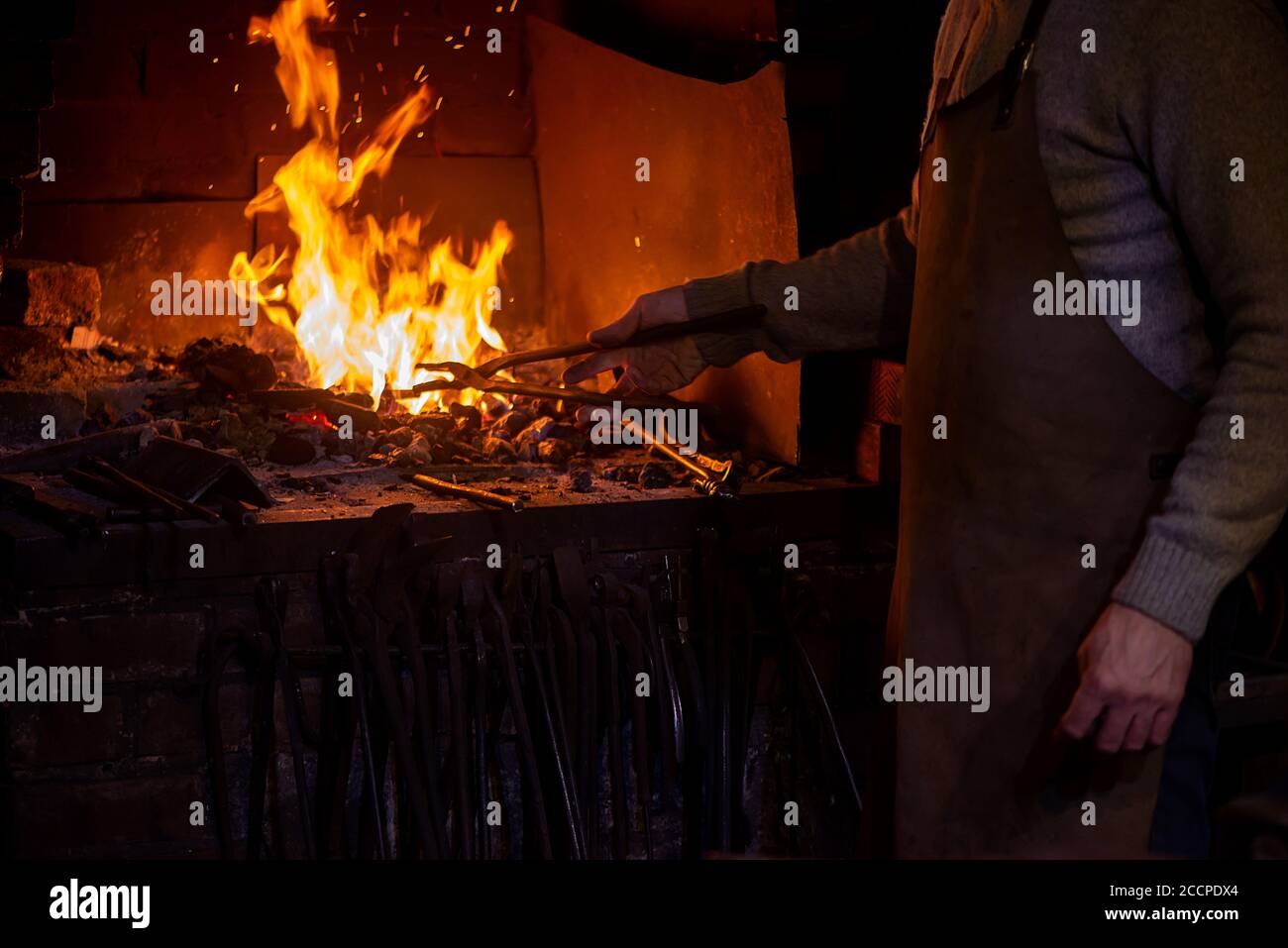Blacksmith working with open fire in furnace. The blacksmith forging ...
