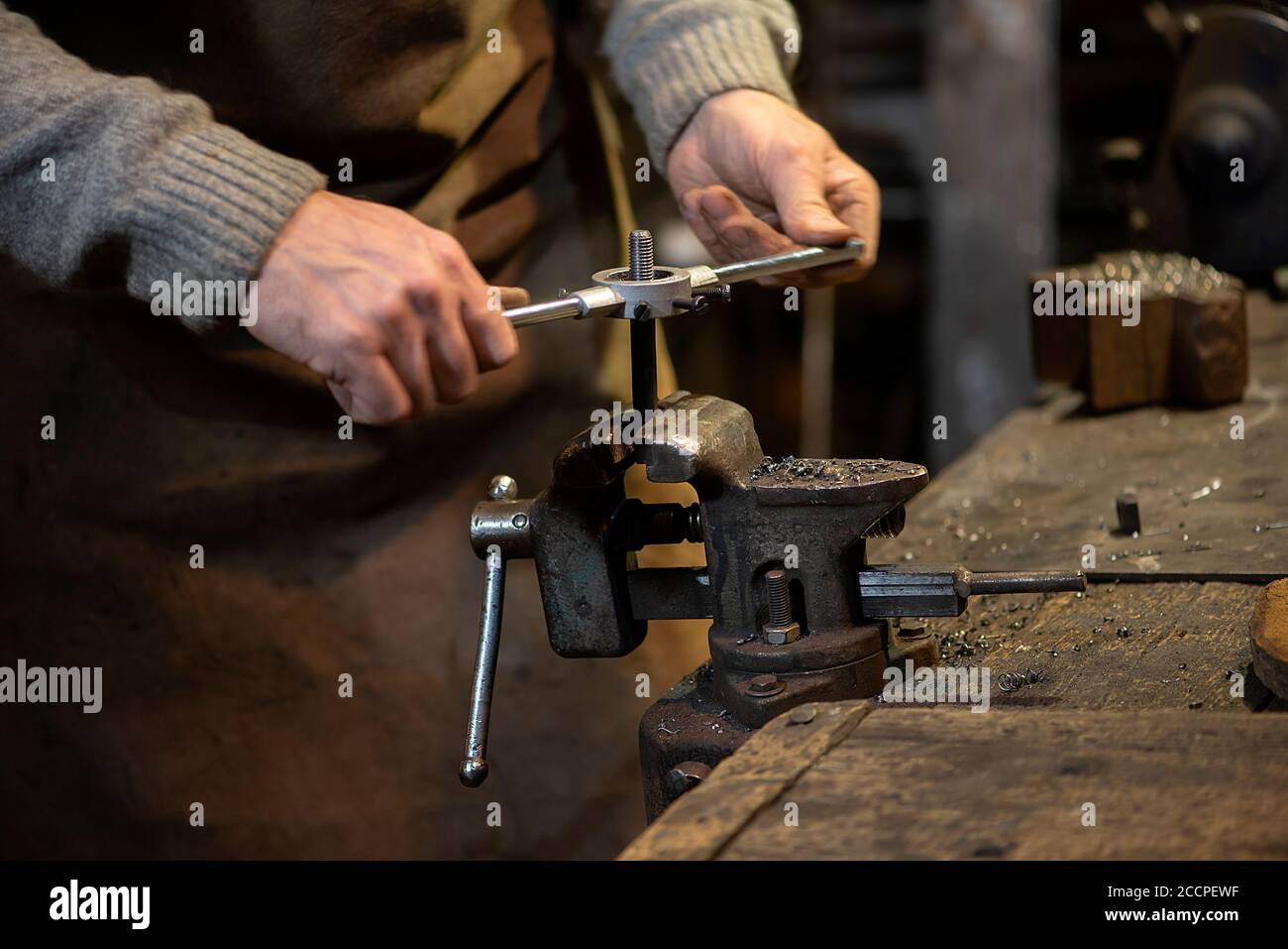 Professional blacksmith working with metal - quenching hot iron part ...