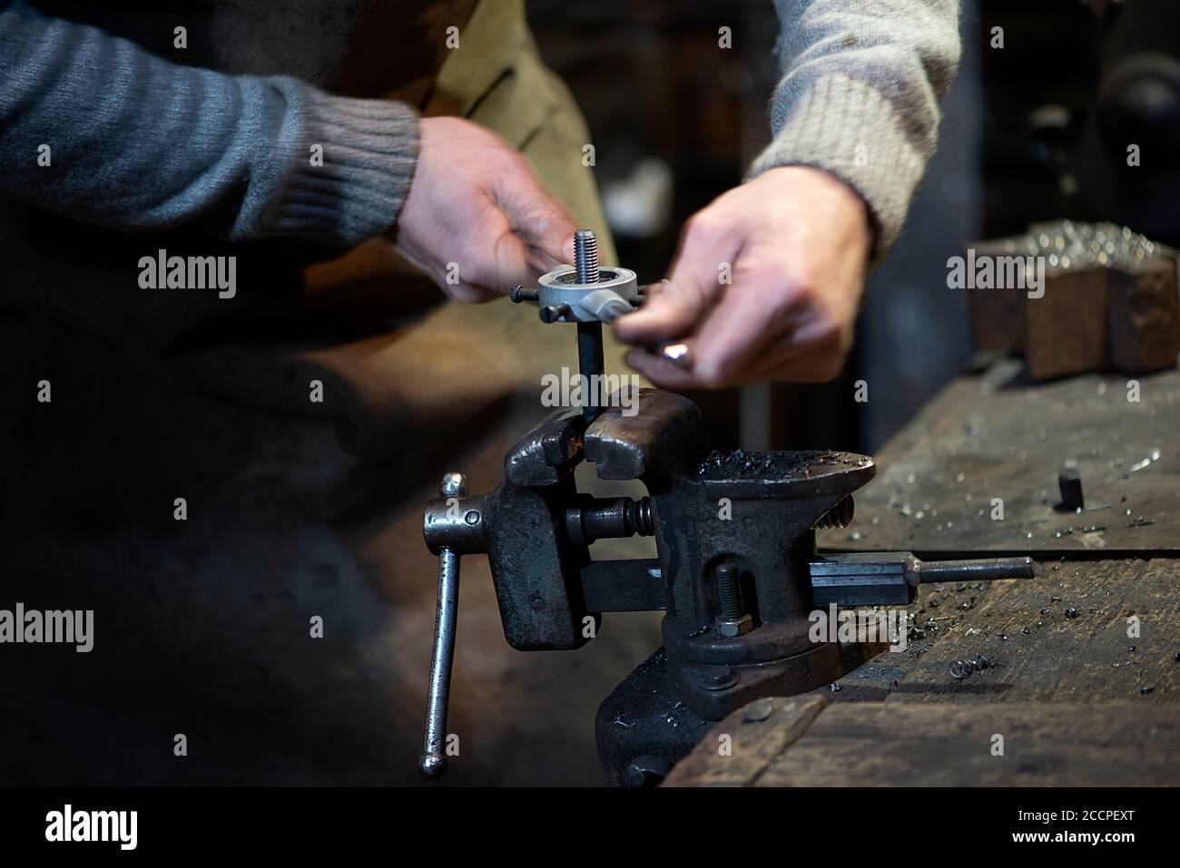 Professional blacksmith working with metal at forge, workshop. Handmade ...