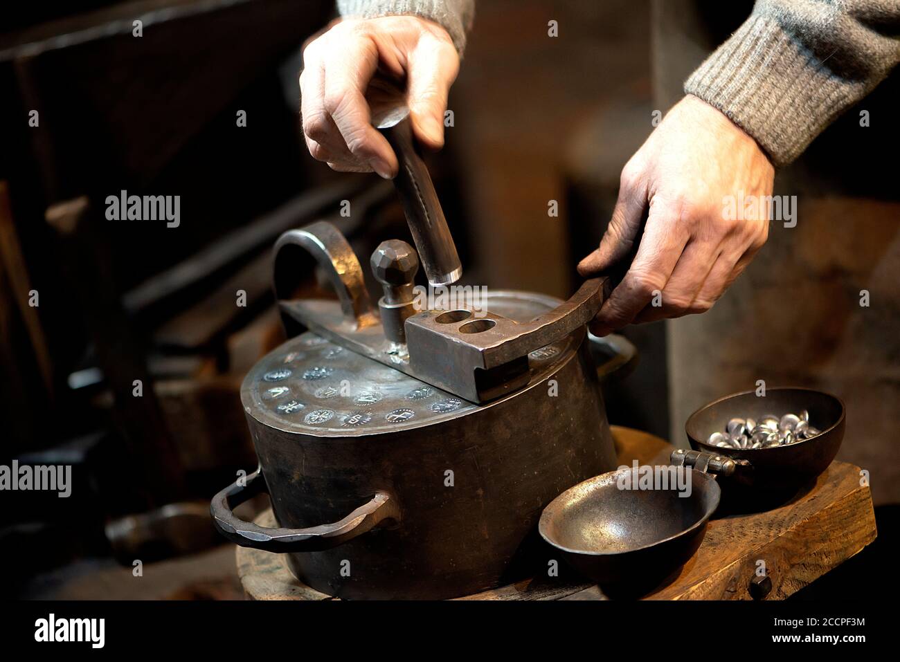 Coinage craftsman stamping coins with hammer and anvil. Vintage style ...
