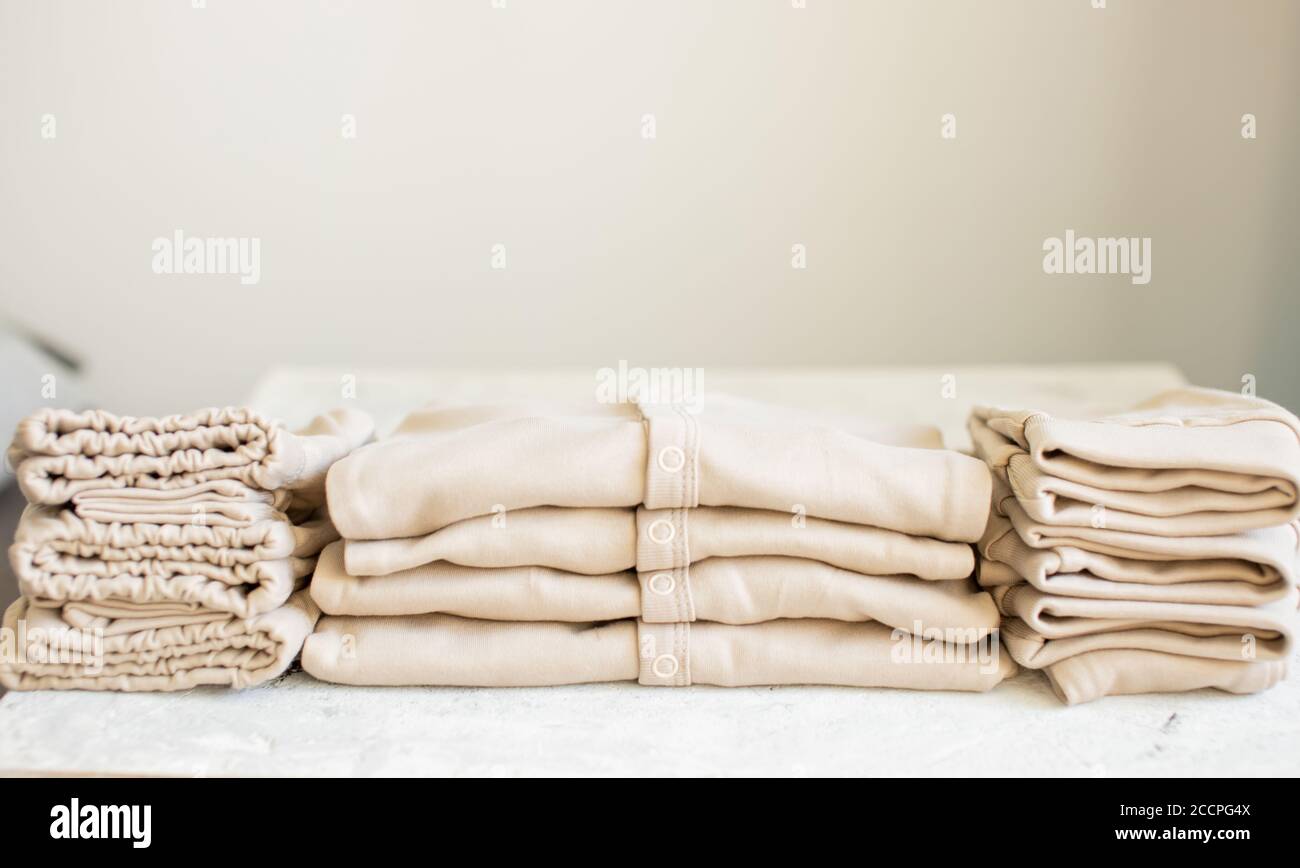 Beautiful beige Baby's clothes on white background Stock Photo - Alamy