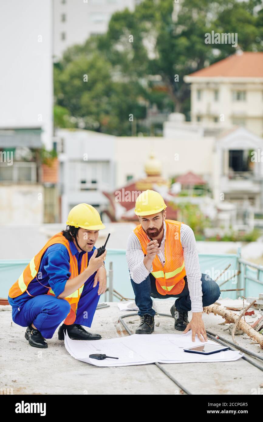Head engineer checking construction plan when contractor controlling ...