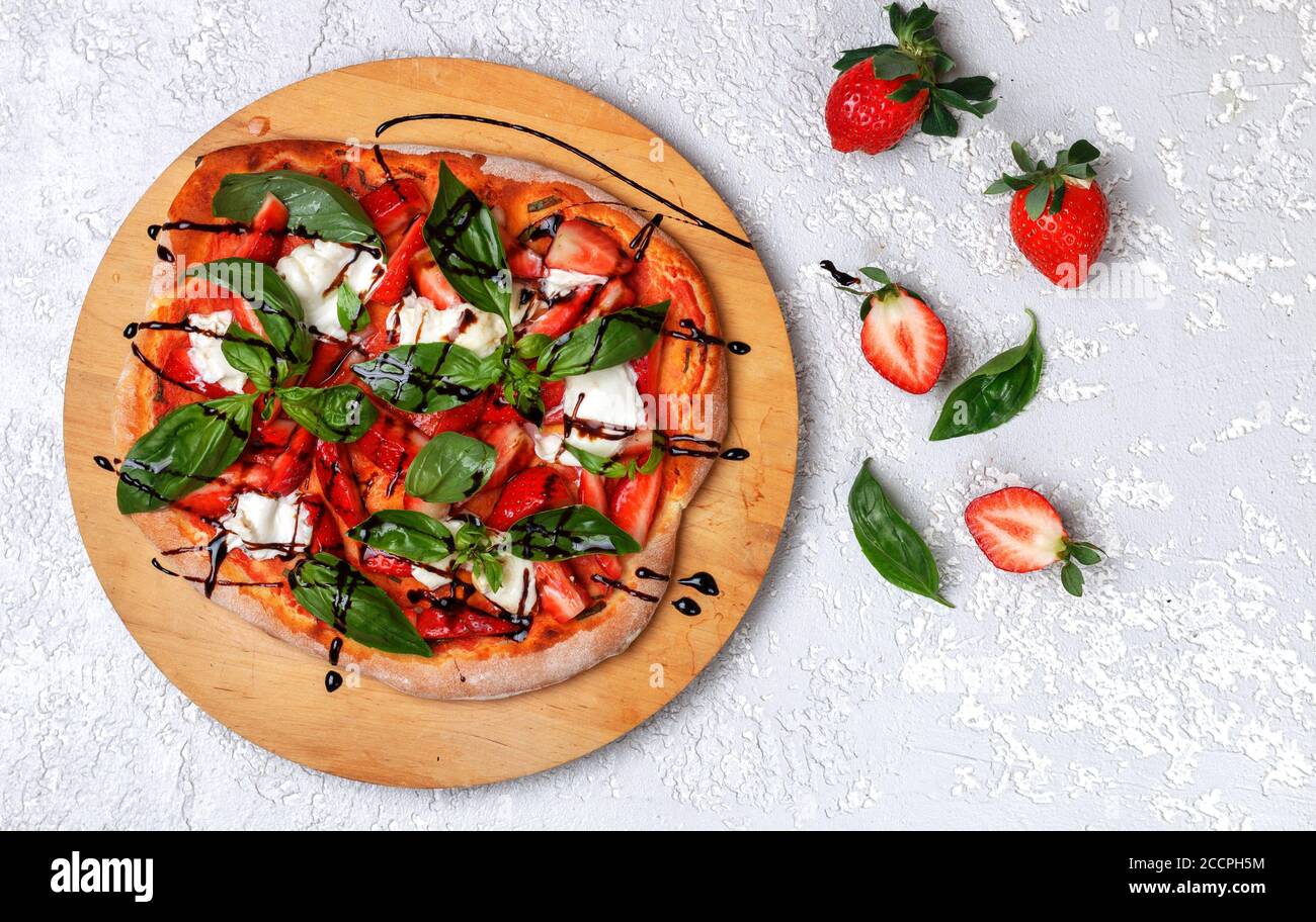 Homemade gourmet pizza with tomato sauce, strawberries, burrata cheese ...