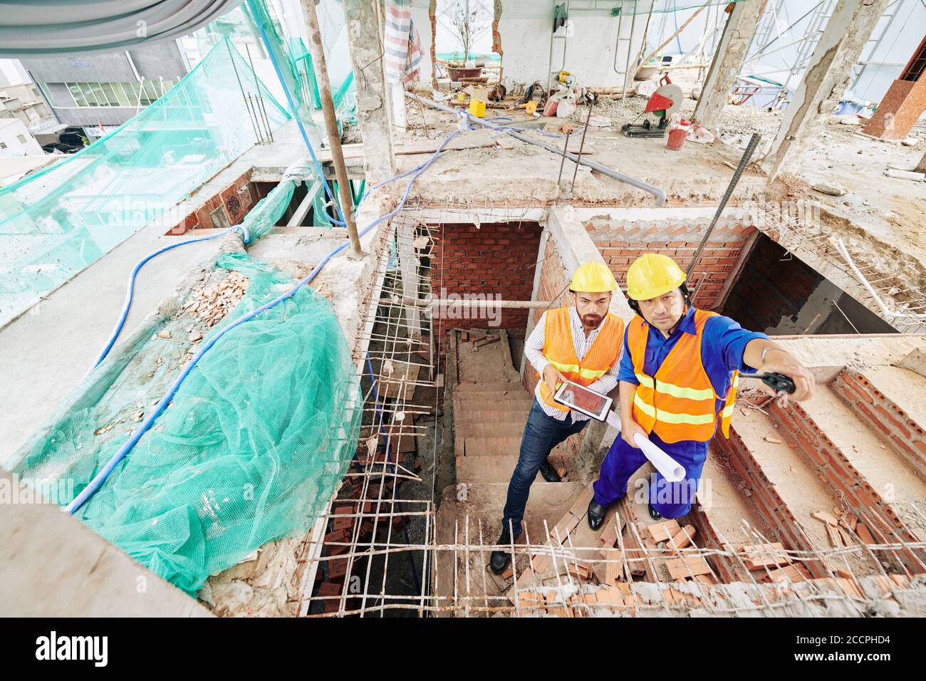 Builder talking to contractor and showing him finished walls in ...