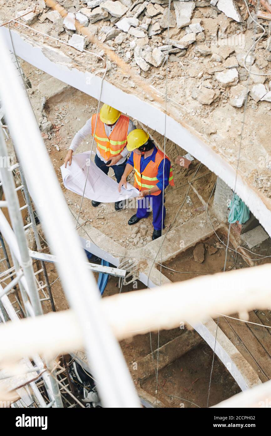 Builders standing on the floor of builing under construction and ...