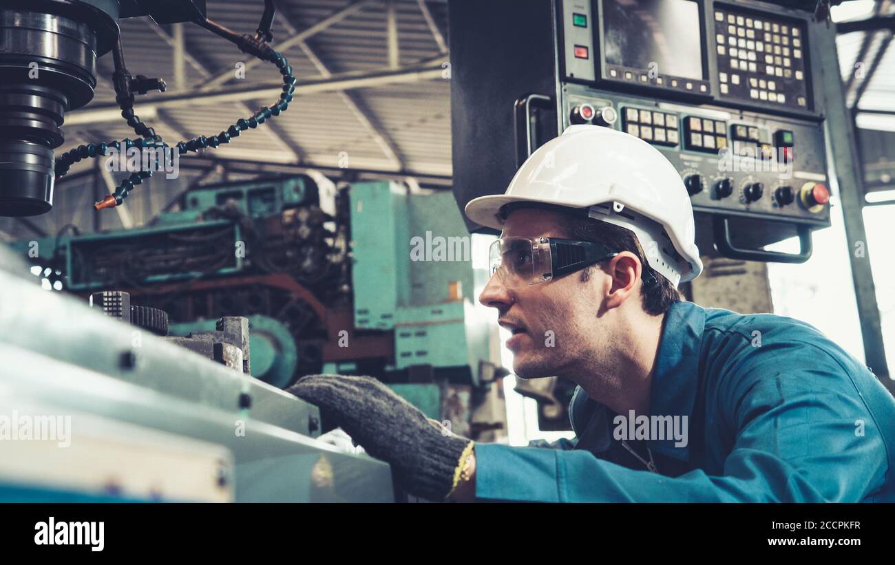 Smart factory worker using machine in factory workshop Stock Photo - Alamy