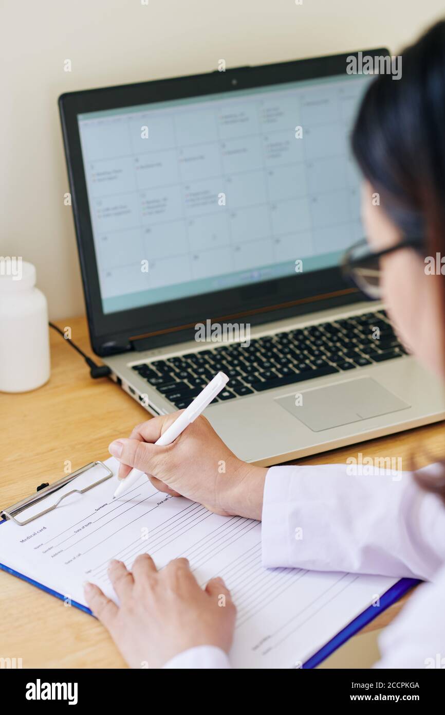 Doctor filling medical history Stock Photo - Alamy