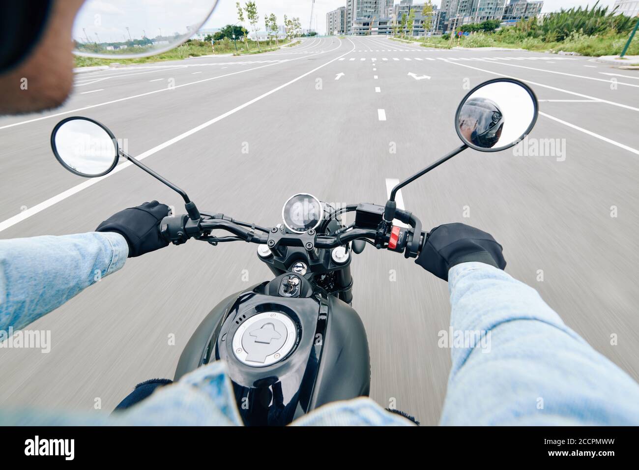 View over handlebar of motorcycle of young man riding fast on highway ...