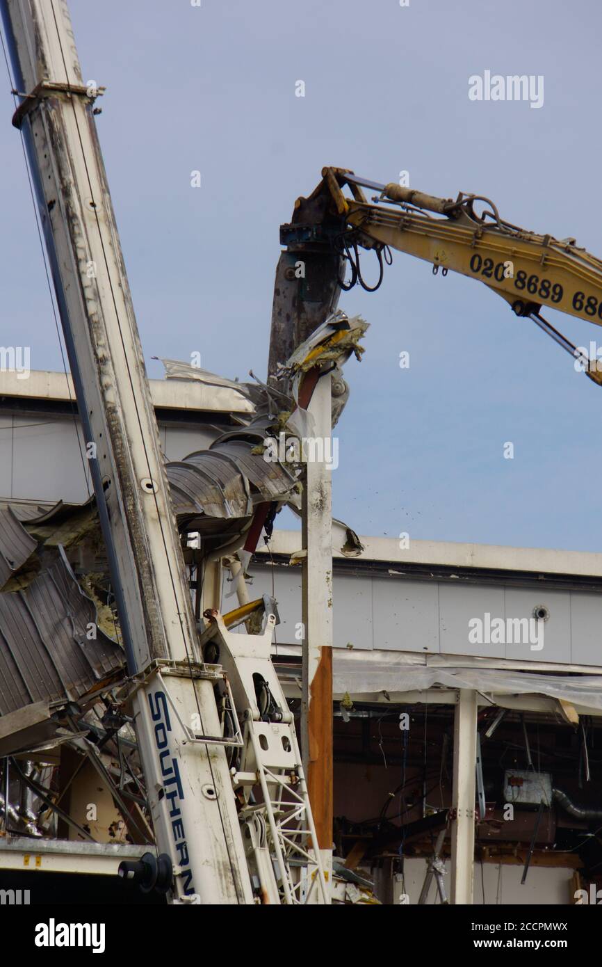 a modern steel structure building being demolished by a machine Stock ...
