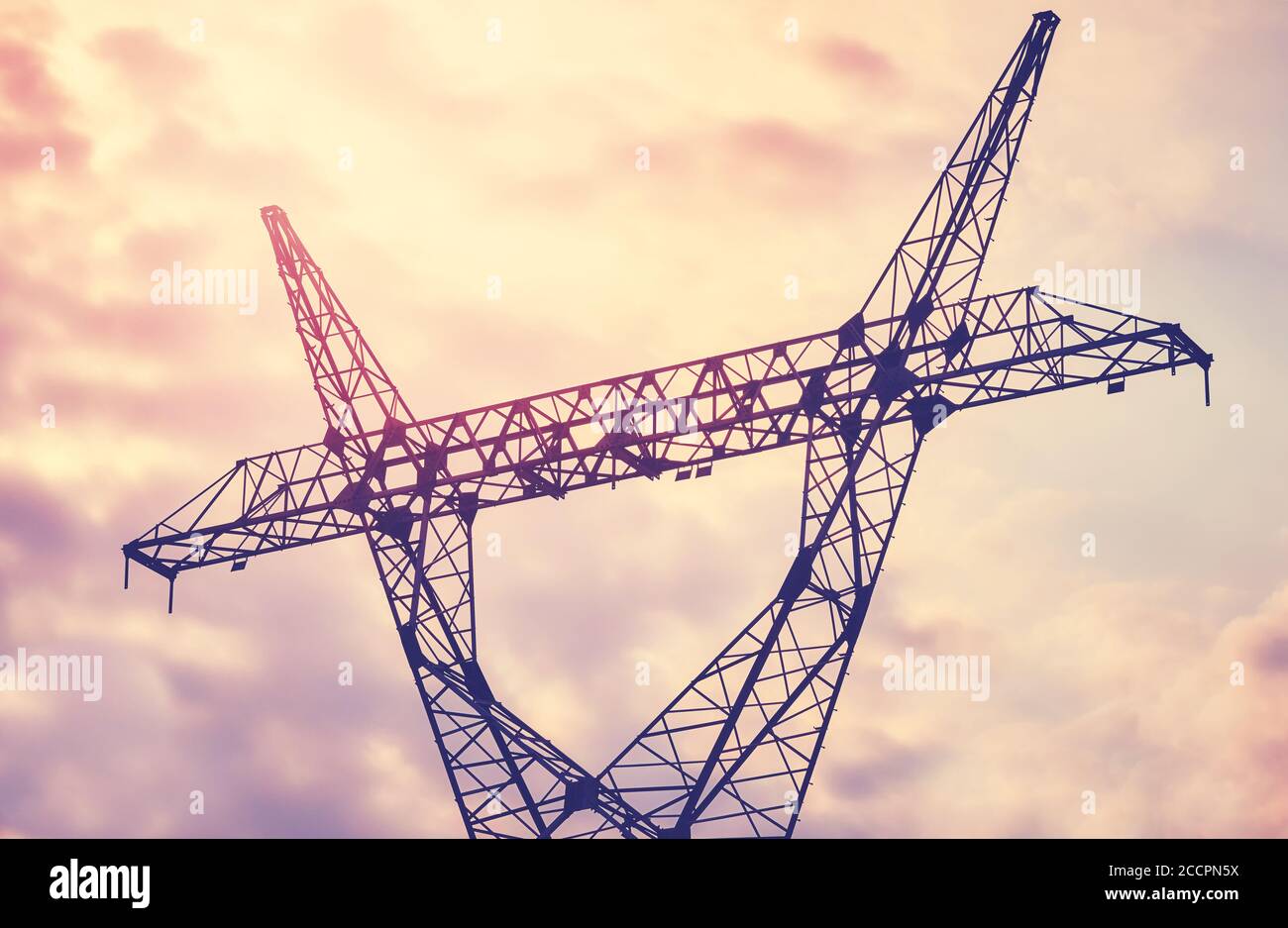 Power transmission tower silhouette at sunset, color toning applied ...
