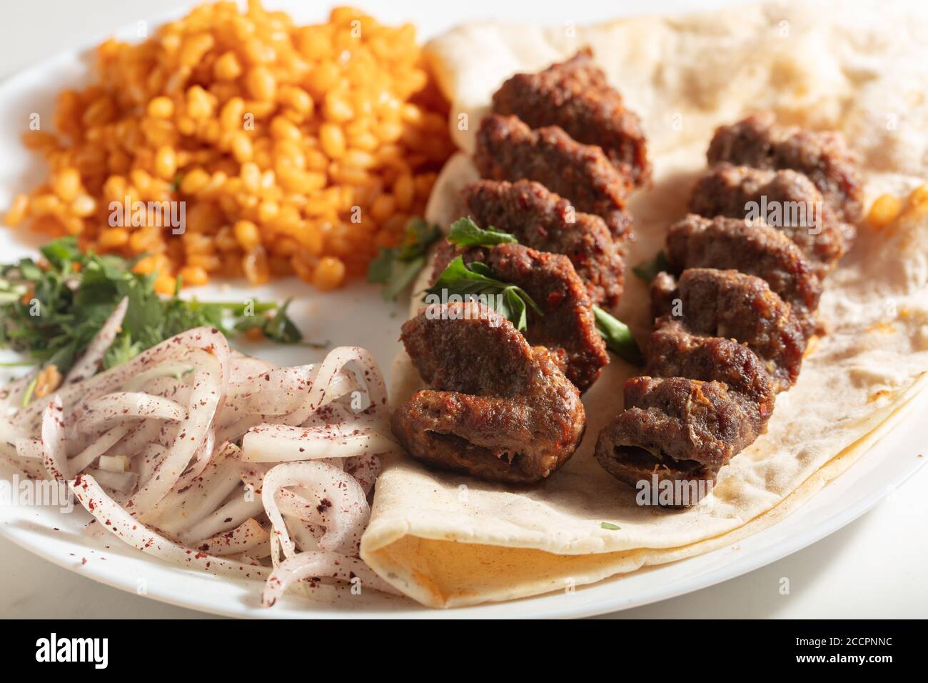 Traditional Adana Kebap with salad Stock Photo - Alamy