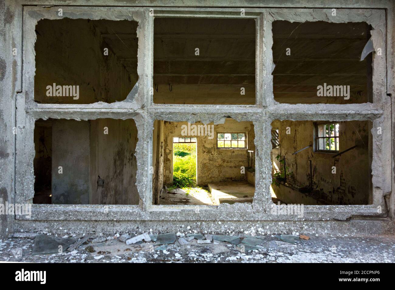 Inside of abandoned building seen through a broken glass window ...