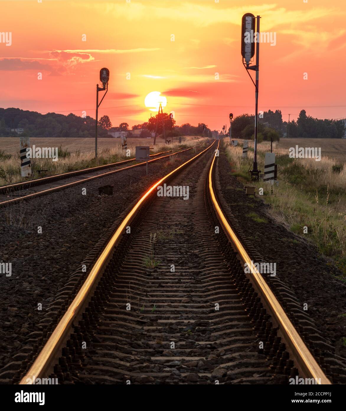 sun is setting over the railroad tracks Stock Photo - Alamy
