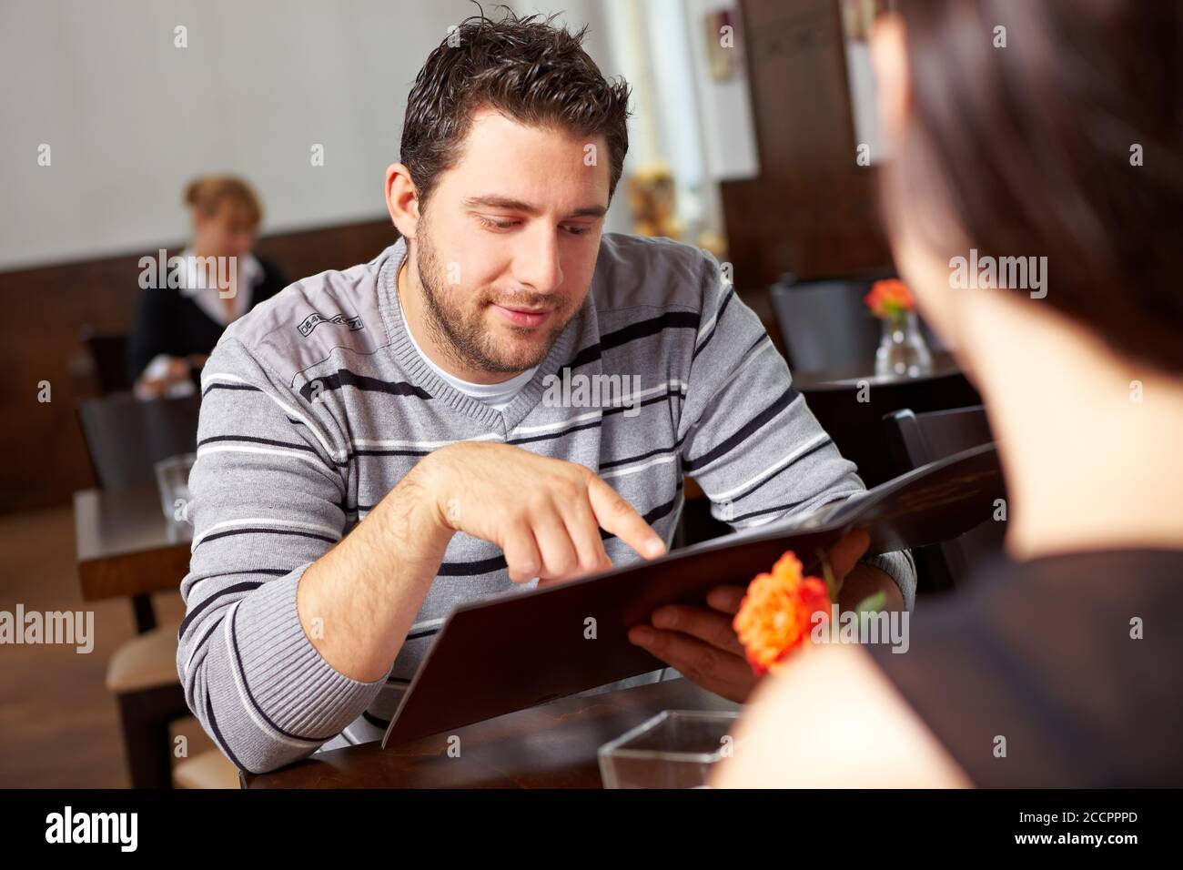 Man and woman choose menu from the menu in a restaurant Stock Photo - Alamy