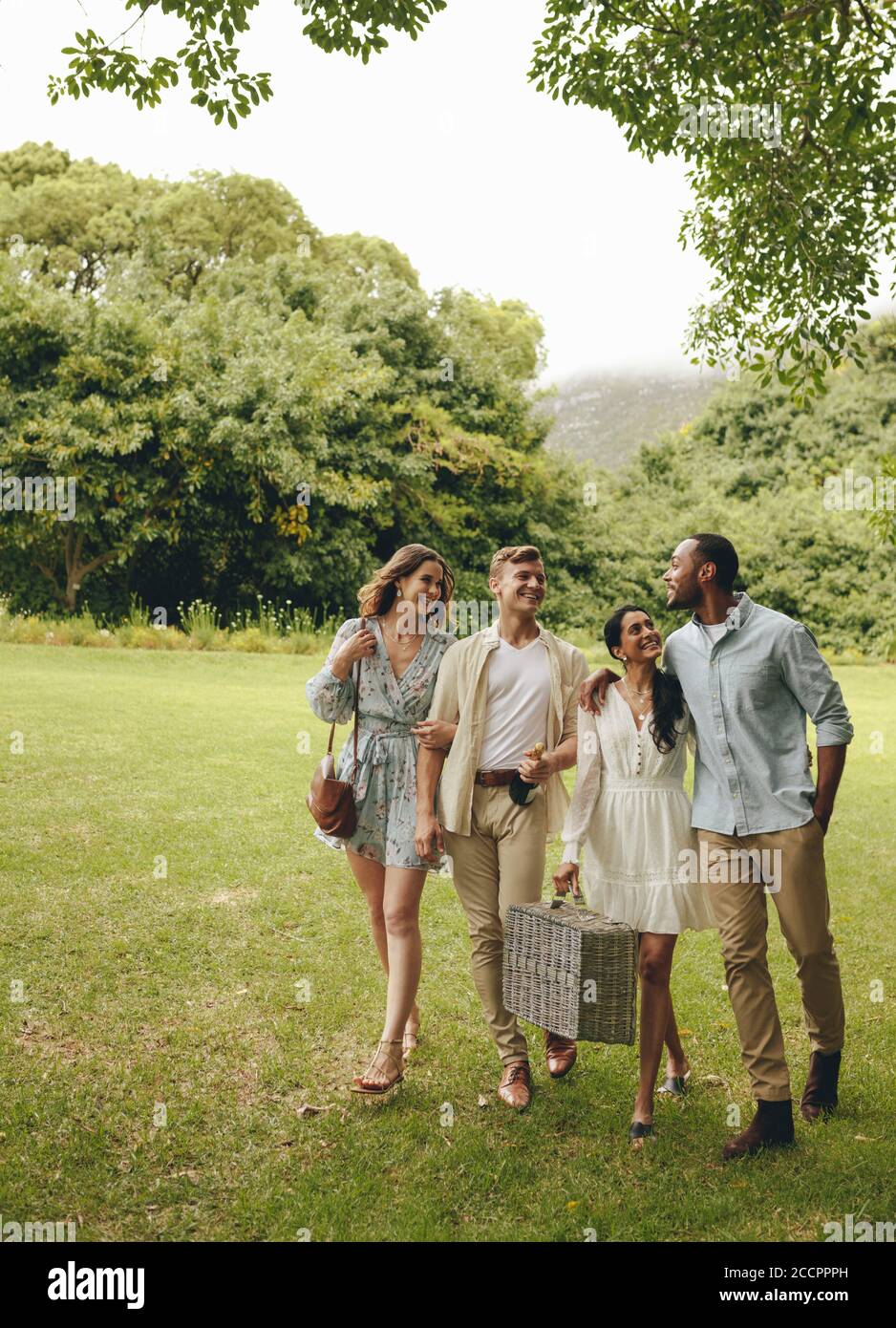 Young people walking together in the park. Smiling men and women ...