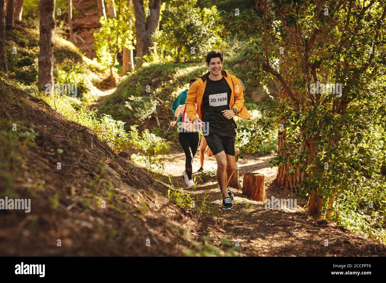 Sports people running on mountain trail. Professional athletes ...