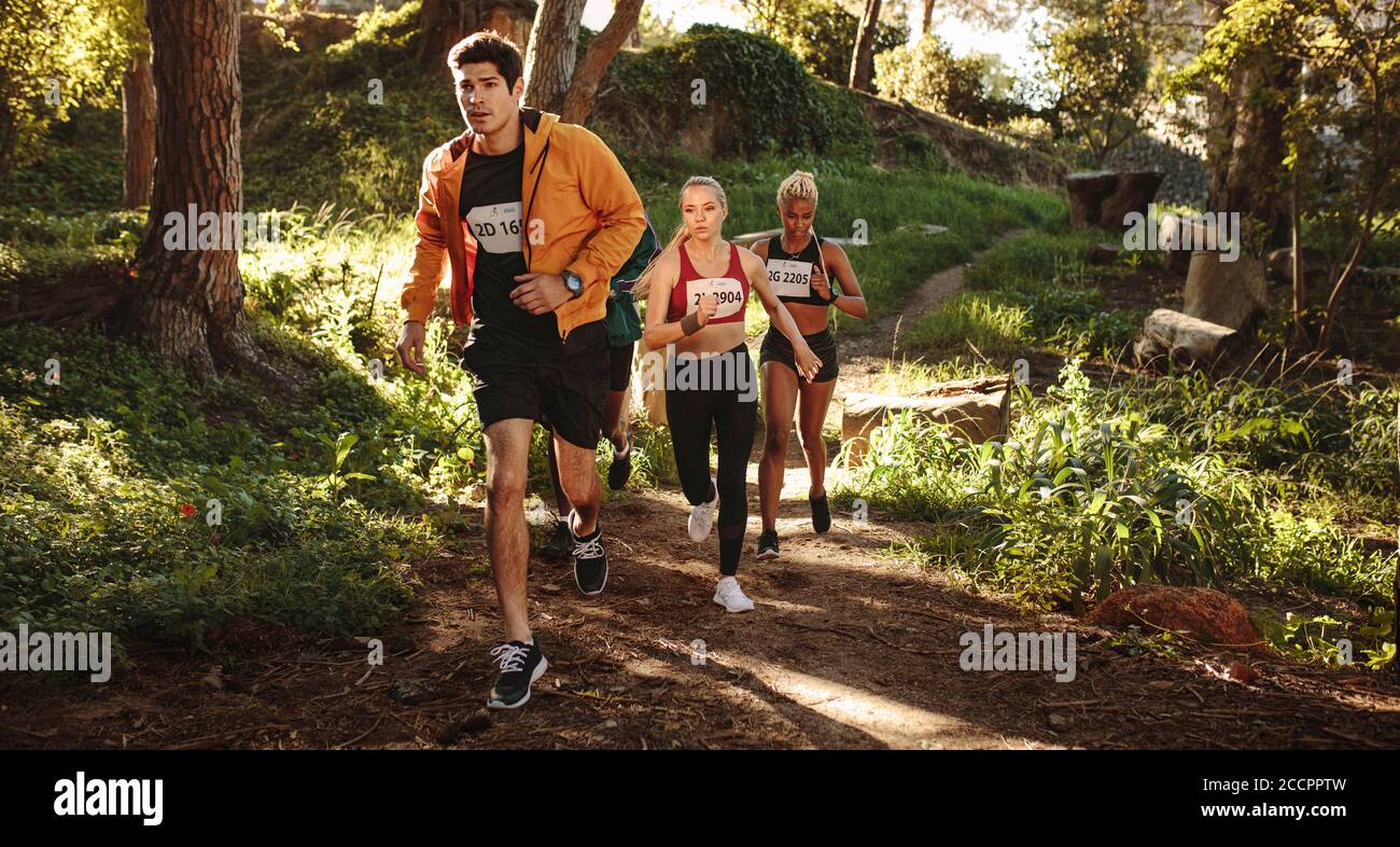 Athletes running on mountain trail. Men and women running a cross ...
