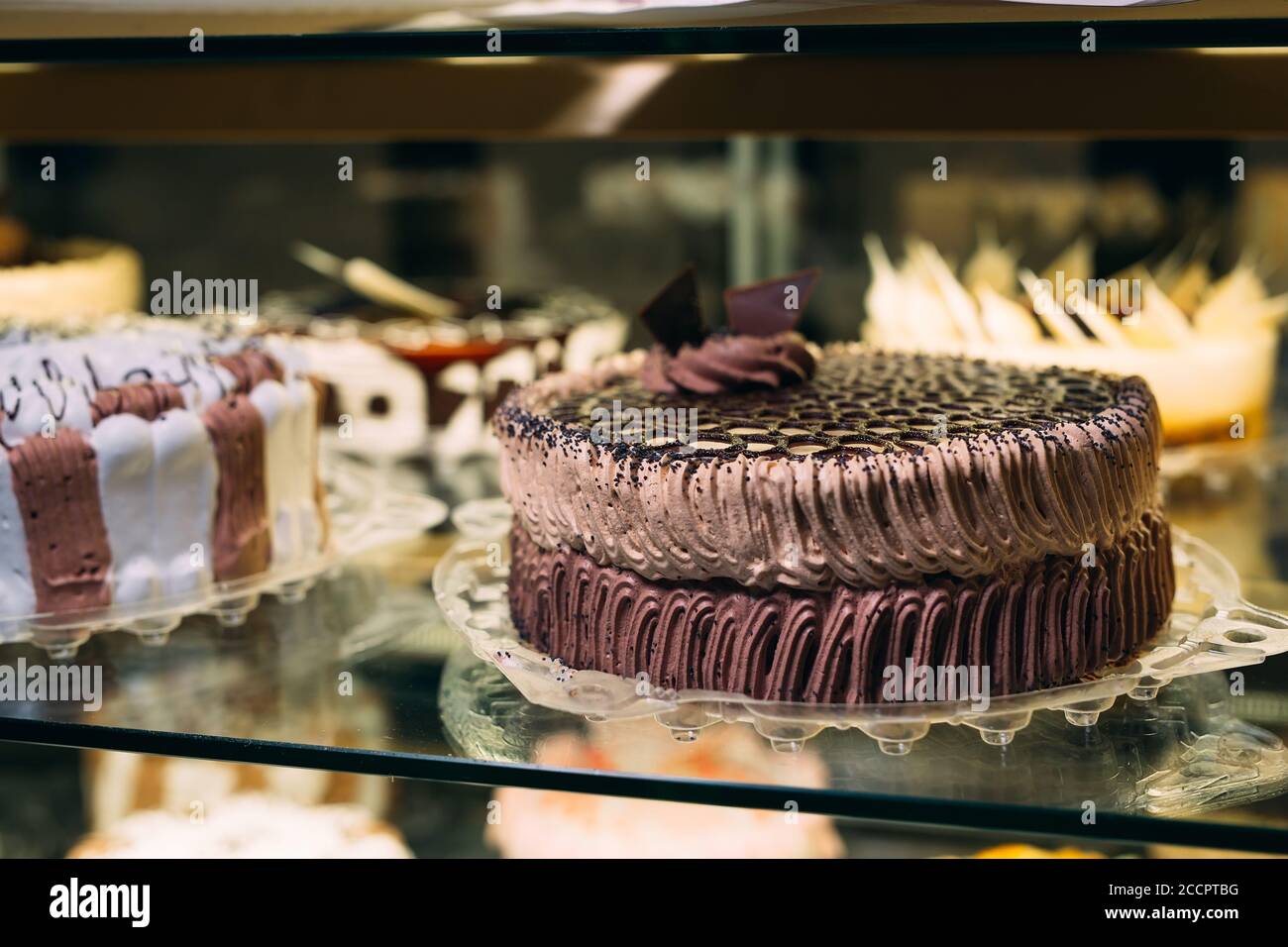 Pastry shop glass display with selection of cream or fruit cake Stock ...