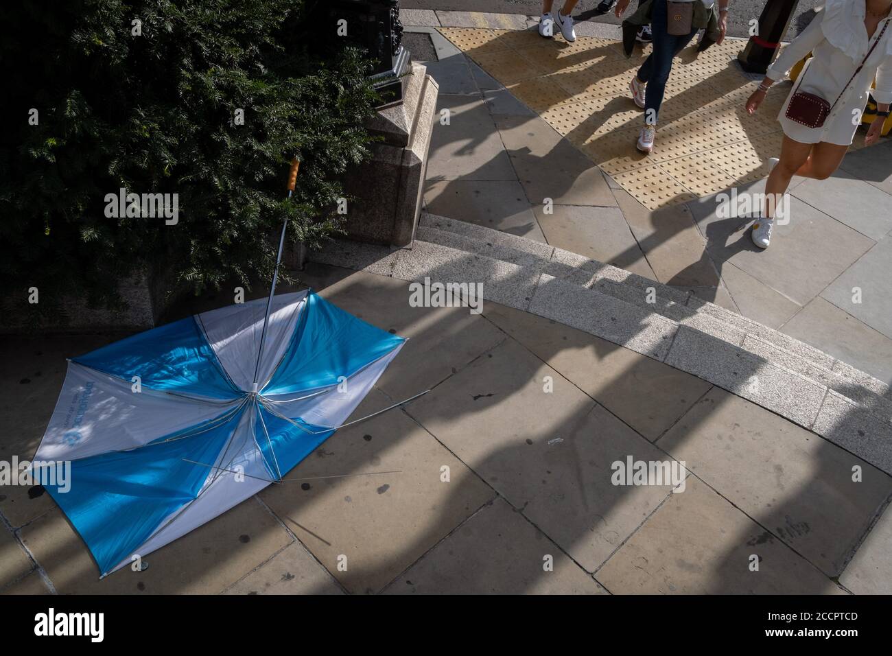 A collapsed brolly lies abandoned on the ground at Bank triangle in the ...