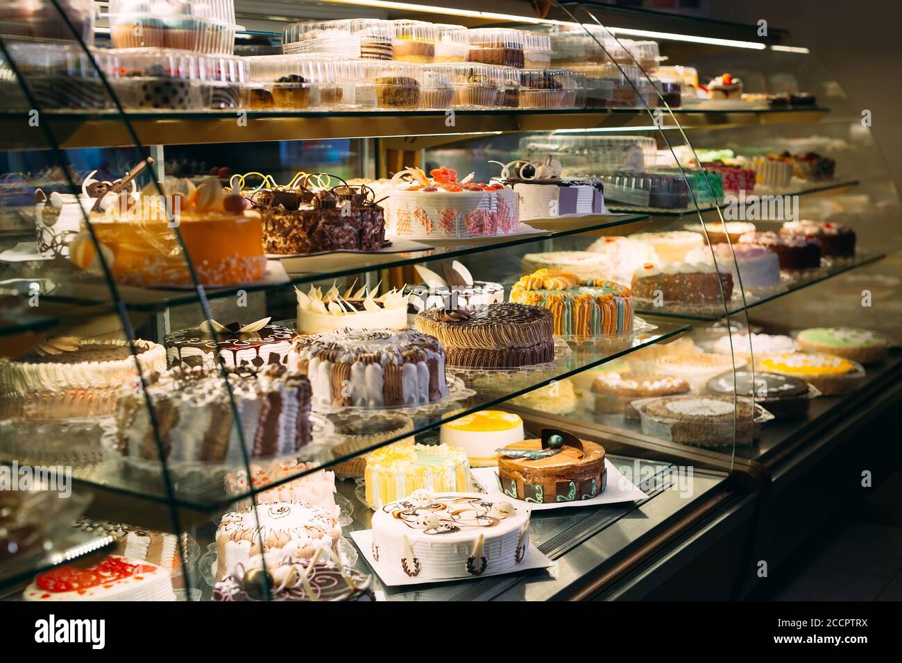 Pastry shop glass display with selection of cream or fruit cake Stock ...