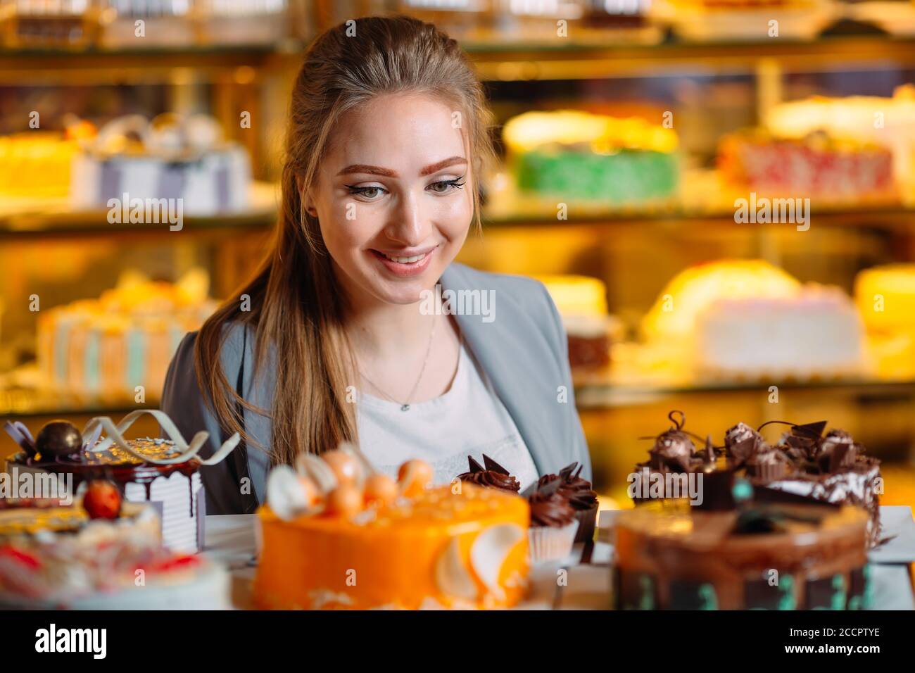 Girl looking at the bakery window with different pieces of cakes Stock ...