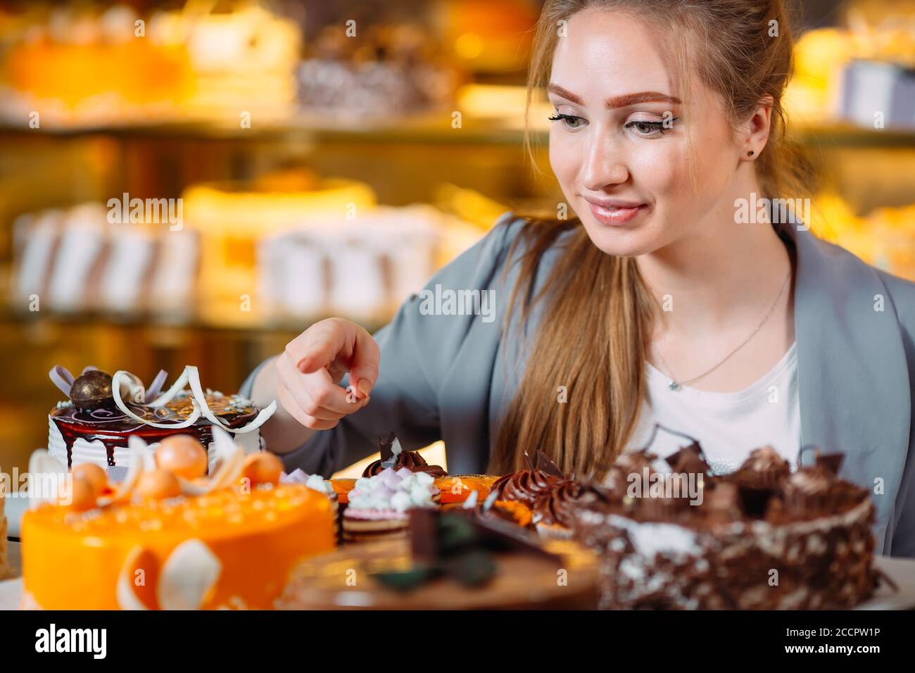 Girl looking at the bakery window with different pieces of cakes Stock ...